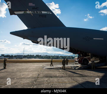 An Air Force loadmaster directs a firetruck off of a C-5 Galaxy at ...