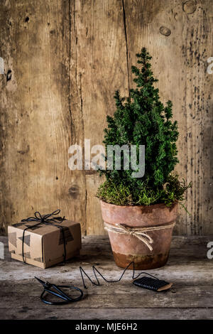 Small Christmas tree with presents on chair near light wall Stock Photo ...