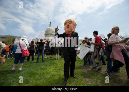 A protestor wearing a Donald Trump paper mache mask at the Tax March ...