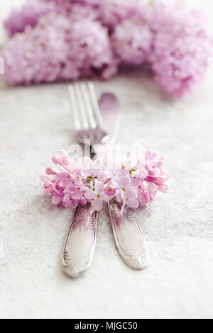 Elegant cutlery, ribbon and flowers on light wooden background Stock ...