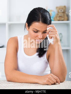 Sad brunette wipes tears with paper handkerchief Stock Photo - Alamy