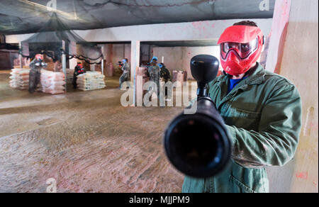 Player in red mask is targeting in enemy in a battlefield in paintball ...