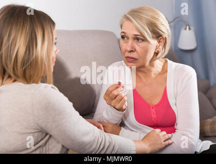 Sappy daughter supports her elderly mother in a difficult moment Stock ...