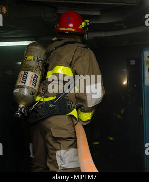 US Navy Firefighting team conducts training in the ship's hangar bay ...