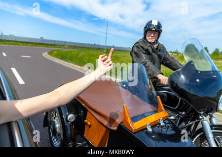 a car driver shows his middle finger to a biker Stock Photo - Alamy