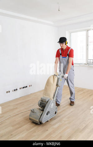 Worker polishing parquet floor with grinding machine Stock Photo - Alamy