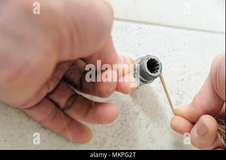 Plumber putting hemp fibers on a thread pipe Stock Photo - Alamy