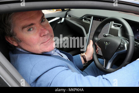 A Tesla electric vehicle sits in a charging station at a dealership ...