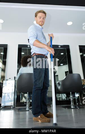 hairdresser mopping floor in a hair-salon Stock Photo - Alamy