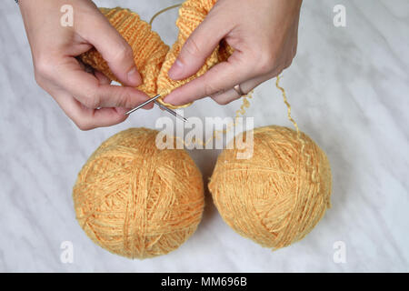 Female hands knitting with gray wool. Close up of knitting wooden ...