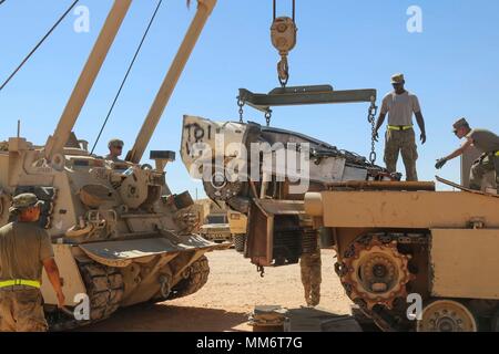 An M88 Armored Recovery Vehicle lifts a truck on snow. Snow and ice can ...