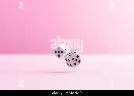 Two dice fall over pink background Stock Photo - Alamy