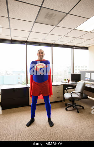 A self satisfied caucasian businessman super hero sits in his office ...