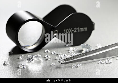 brilliant cut diamonds with folding magnifier on wooden background ...