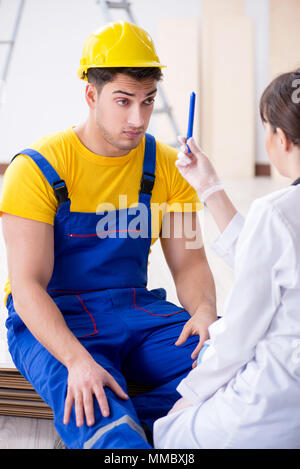 Doctor helping injured worker at construction site Stock Photo - Alamy