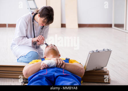 Doctor helping injured worker at construction site Stock Photo - Alamy