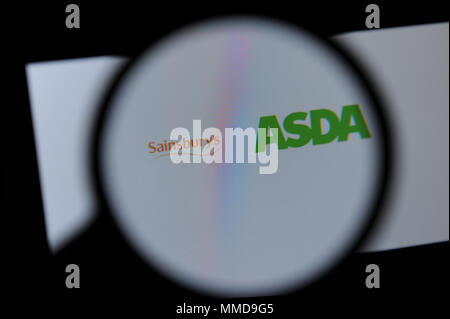The Sainsbury's and Asda logos seen through a magnifying glass Stock ...