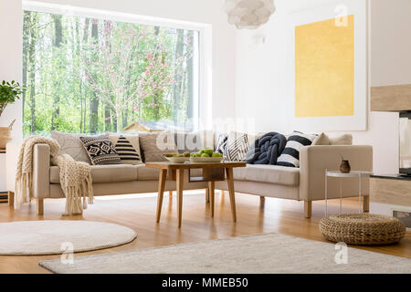 Comfortable white sofa and wooden coffee table with books on yellow ...