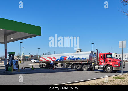 Gasoline or petrol tank truck supplying or off loading fuel at a retail ...