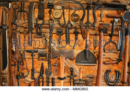 Antique tools hanging on a farm shop wall Stock Photo - Alamy