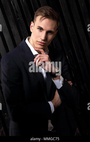 Confident handsome man with strained look posing in blue fashion suit ...