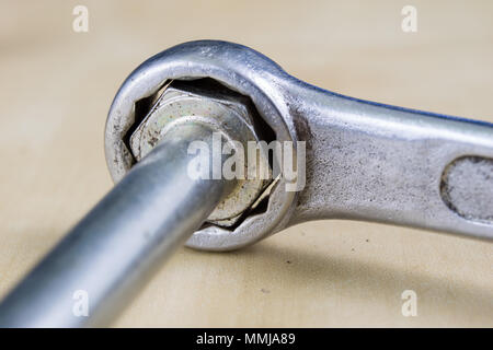 Metric screw and key on a wooden table. Mechanical accessories in the ...