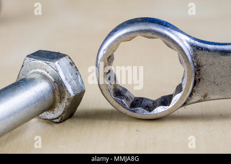 Metric screw and key on a wooden table. Mechanical accessories in the ...