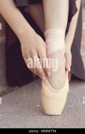 A closeup ballerina's legs in pointe shoes wrapped up in holiday lights Stock Photo - Alamy