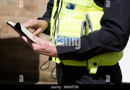 Police officer reading from a black note book Stock Photo - Alamy