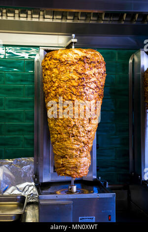 Turkish shawarma roasting on vertical skewer Grilled skewered chicken ...