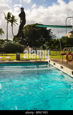 A U.S. Marine jumps into a pool during annual swim qualification aboard ...