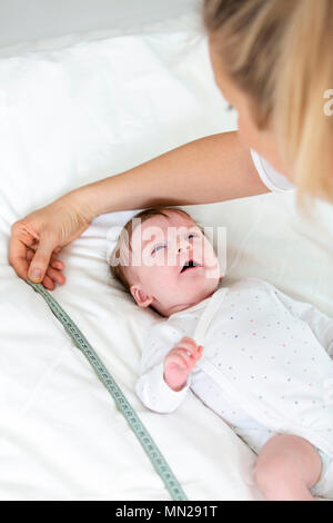 Baby is being measured by mother, doctor, woman Stock Photo - Alamy