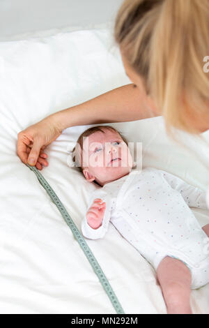 Baby is being measured by mother, doctor, woman Stock Photo - Alamy