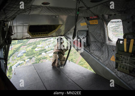 A Royal Marine Aircrewnan looks out the side of a Merlin Mk2 Helicopter ...