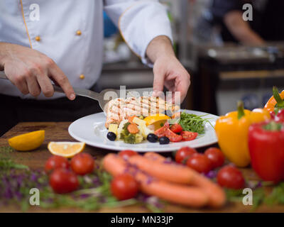 cook chef decorating garnishing prepared meal dish on the plate in ...