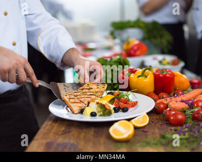 cook chef decorating garnishing prepared meal dish on the plate in ...