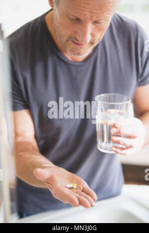 man taking his vitamins Stock Photo - Alamy