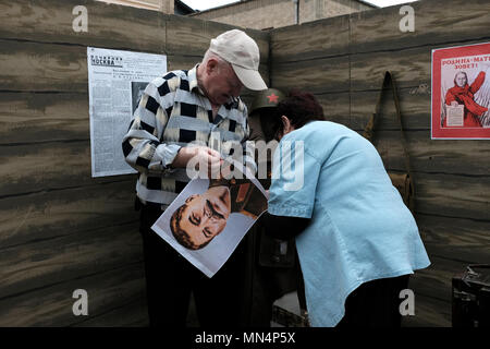 Civilians hold a poster with the photo of Stalin as they set up a ...