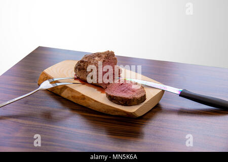 Rare underdone sliced rib beef ober wooden plate Stock Photo - Alamy