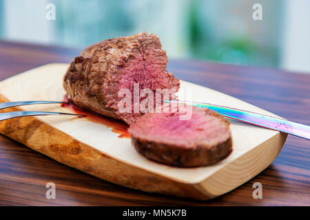 Rare underdone sliced rib beef ober wooden plate Stock Photo - Alamy