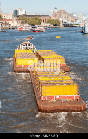 Tug tows barges holding yellow shipping containers filled with general ...