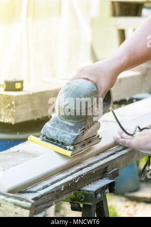 a handyman is sanding outdoors Stock Photo - Alamy