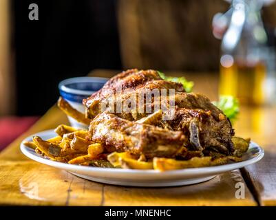 Spare ribs with potato wedges and okra Stock Photo - Alamy
