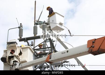 Utility company line man working from a bucket lift to repair and ...