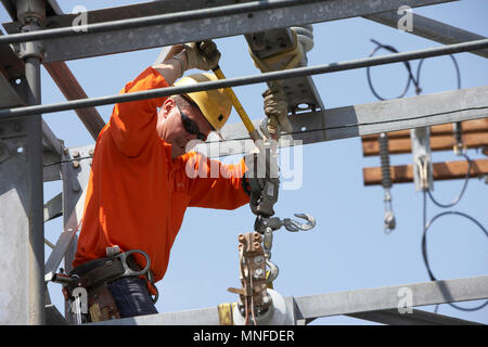 Utility workman wearing hardhat installing new equipment on an ...