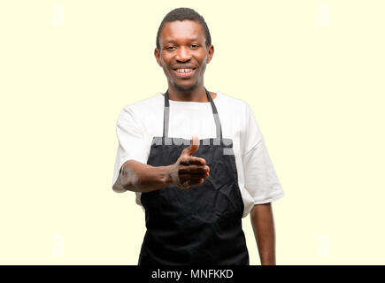 African man shop owner wearing apron happy and excited celebrating ...