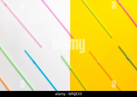 Pastel neon drinking straws isolated on white and yellow background ...