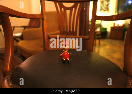 Pinocchio seating on the office chair Stock Photo - Alamy