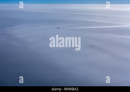 A plane flights above the thick layer of clouds Stock Photo - Alamy