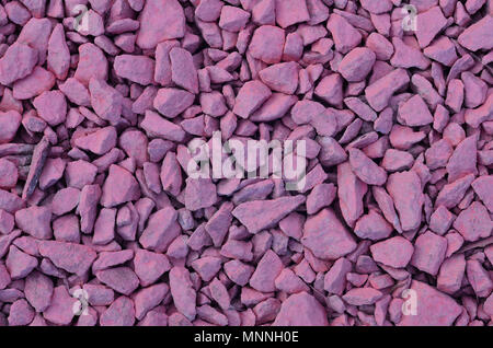 Gravel pile with white gray pink stones in front of brown wooden fence ...